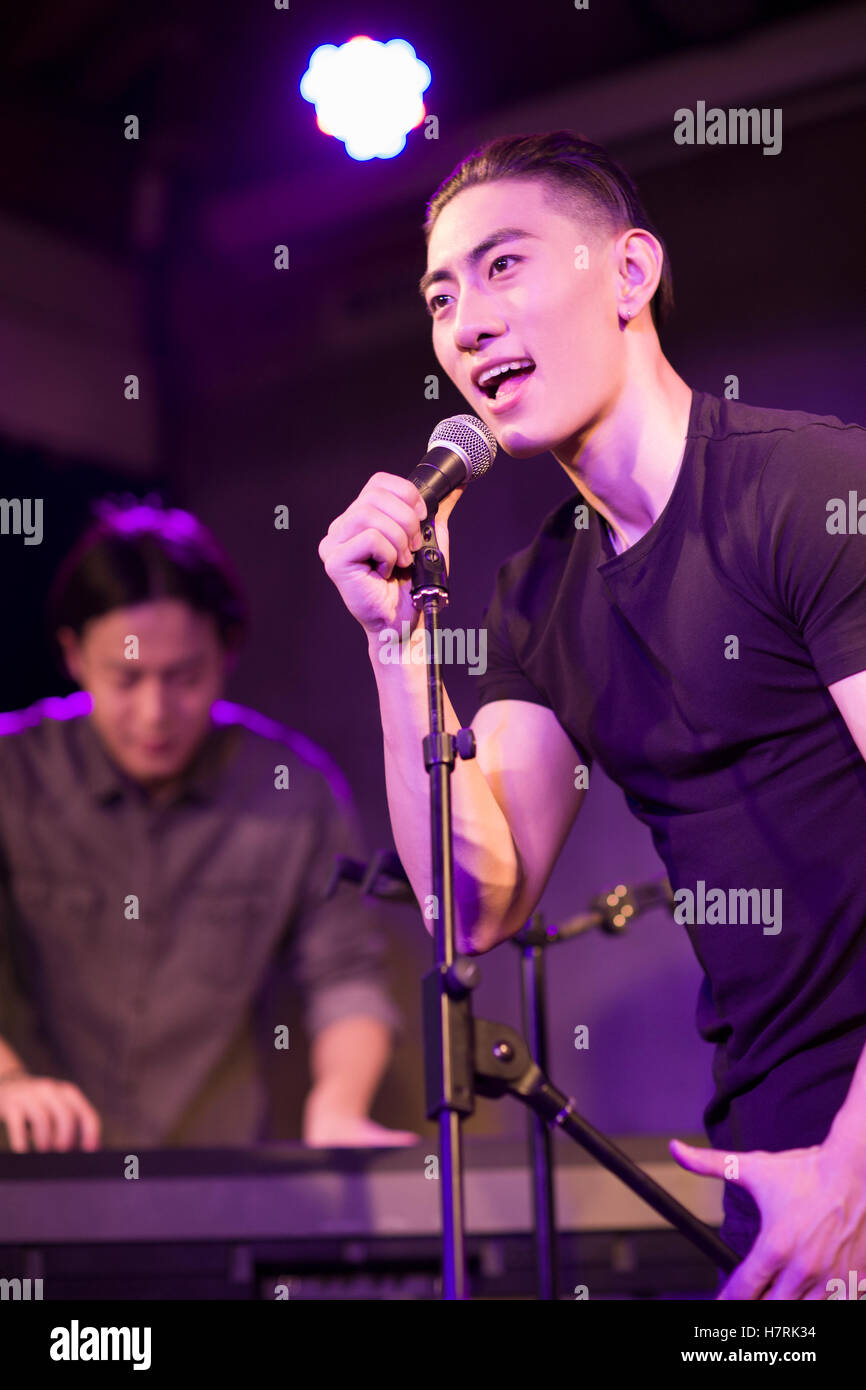Young Chinese man singing on stage Stock Photo - Alamy
