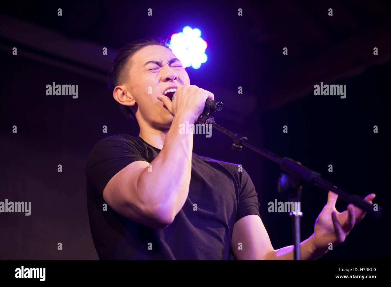 Young Chinese man singing on stage Stock Photo - Alamy
