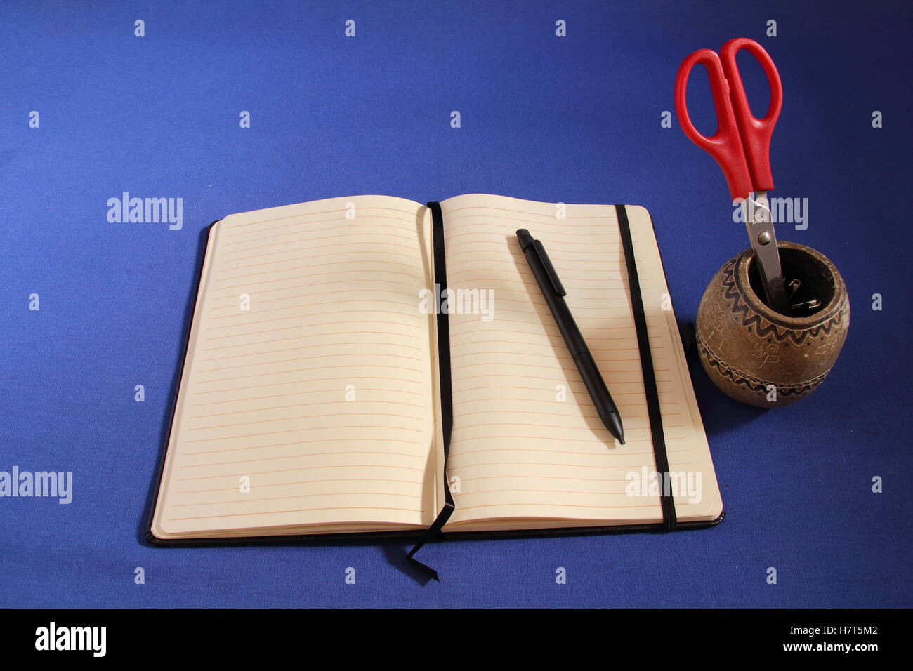 The surface of a desk in an office with an open diary a pen and other ...