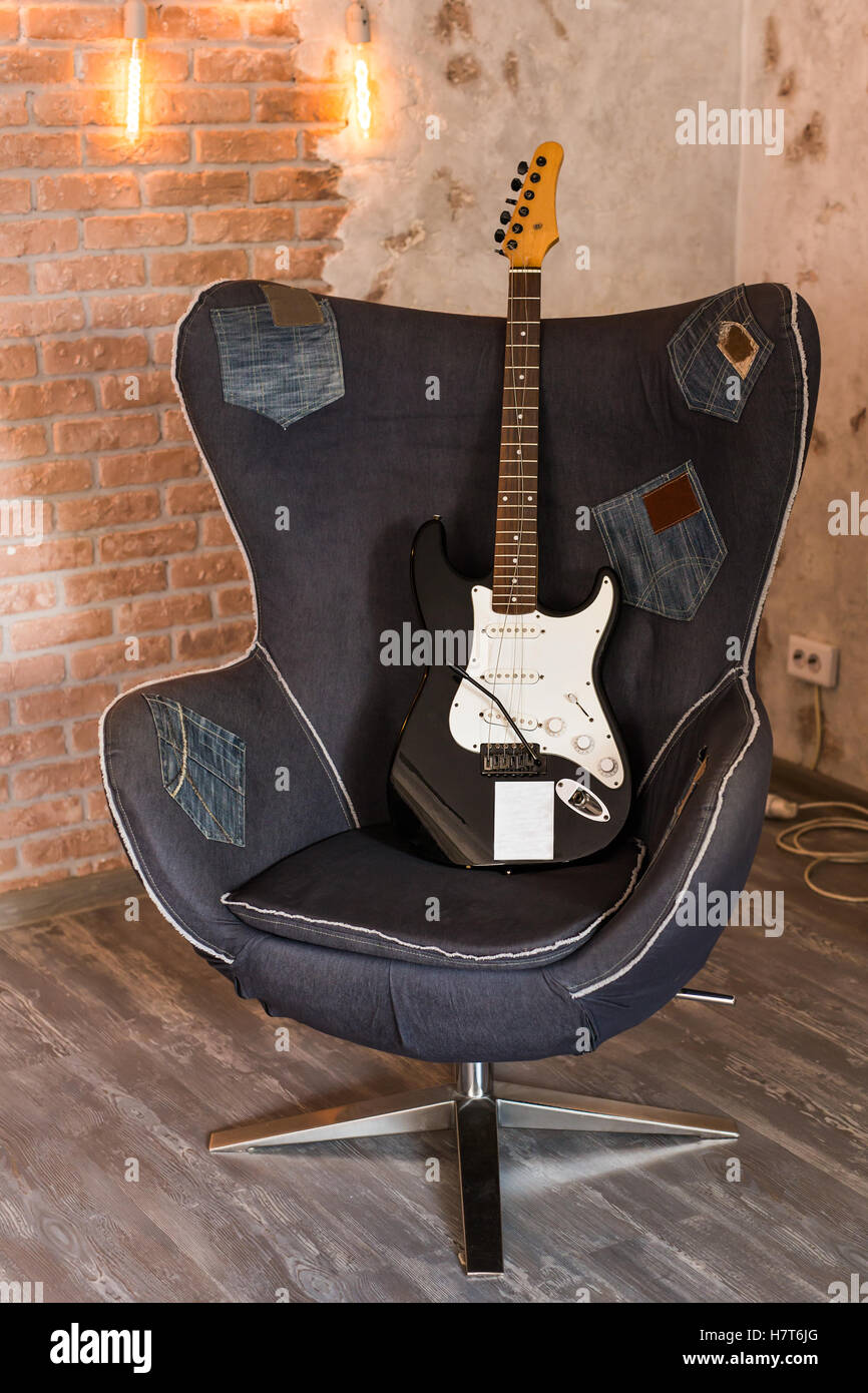 Electric guitar on a chair Stock Photo - Alamy