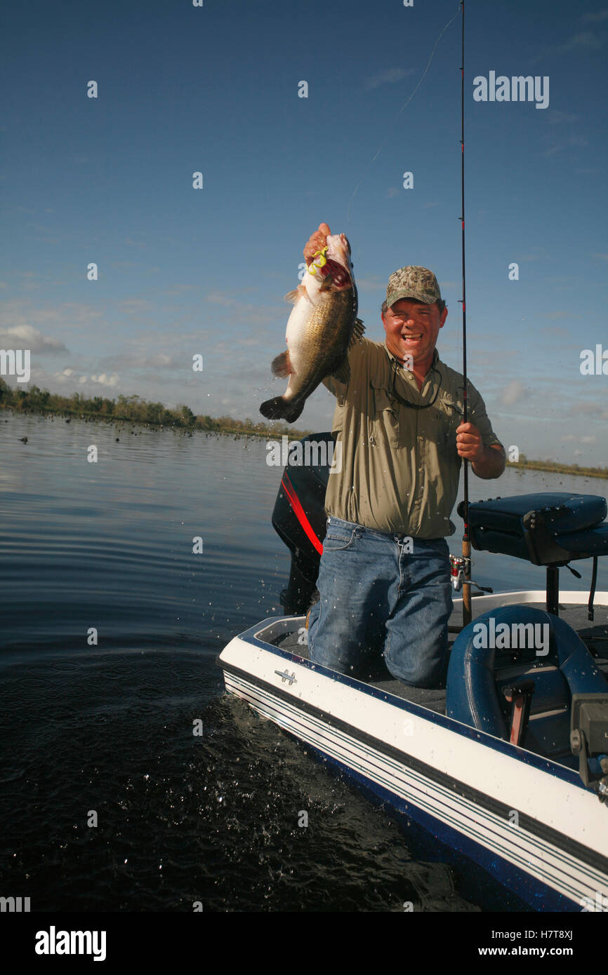 Bass Fisherman With Fish On Boat Stock Photo - Alamy