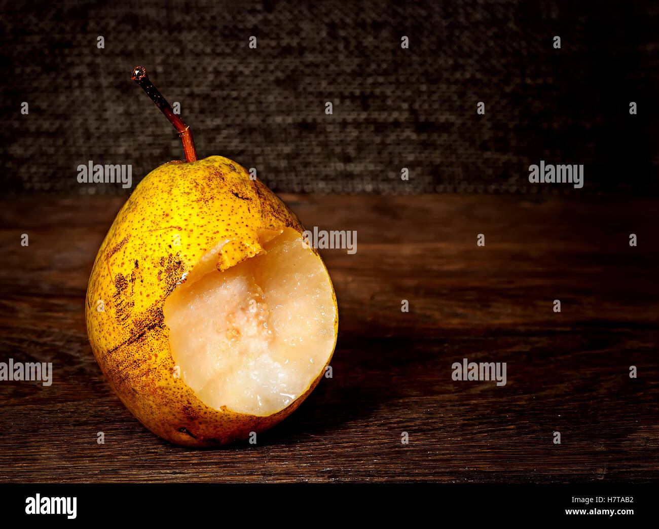 One bitten pear on a wooden table background a sacking Stock Photo - Alamy