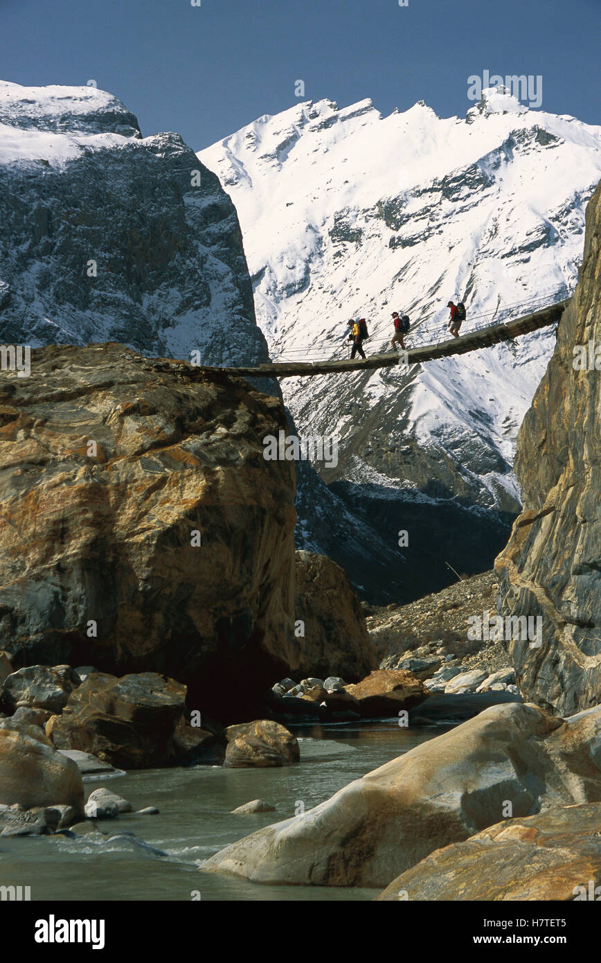 Trekkers cross a swing bridge over the Braldu River en route to Baltoro ...