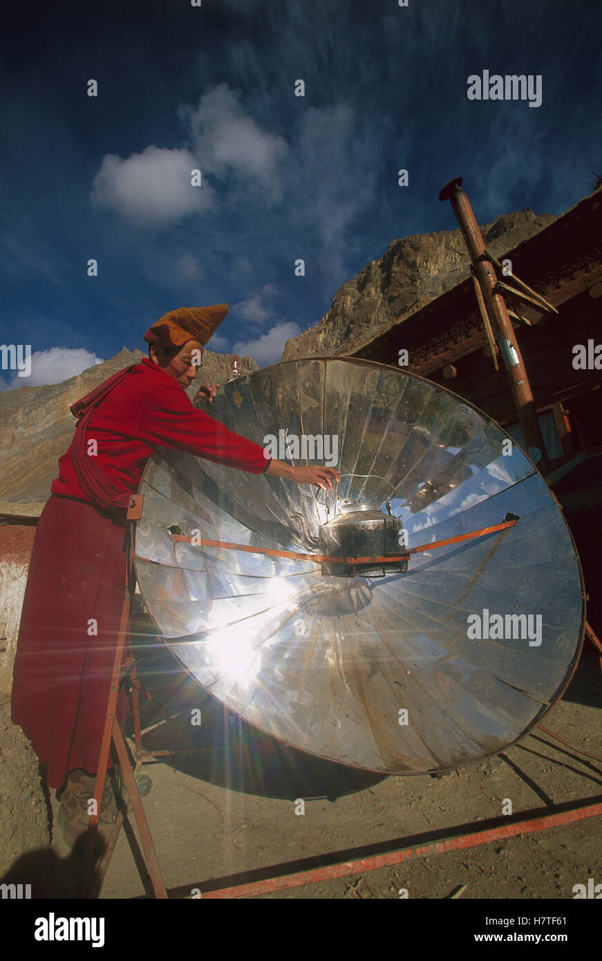 Monk boiling water with solar reflector, Lingshet Monastery, Ladakh ...