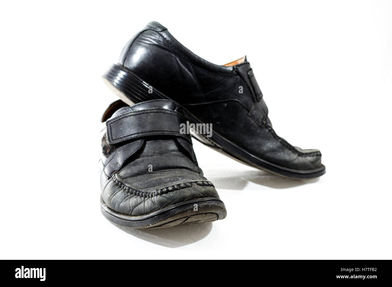 Old used and worn black leather shoes on a white background Stock Photo ...