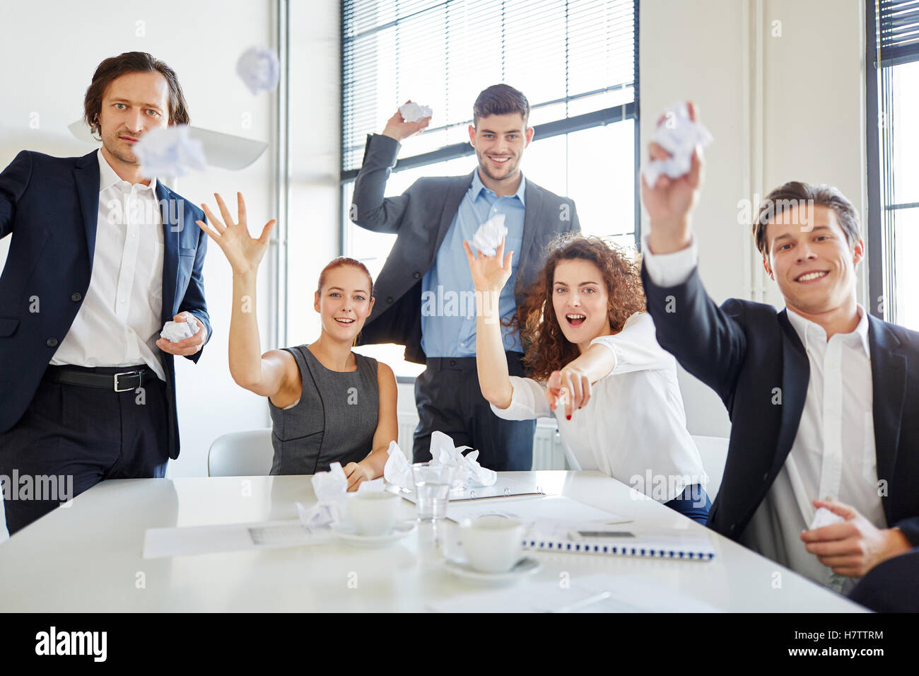 Start-up team throwing paper balls and playing in seminar Stock Photo ...