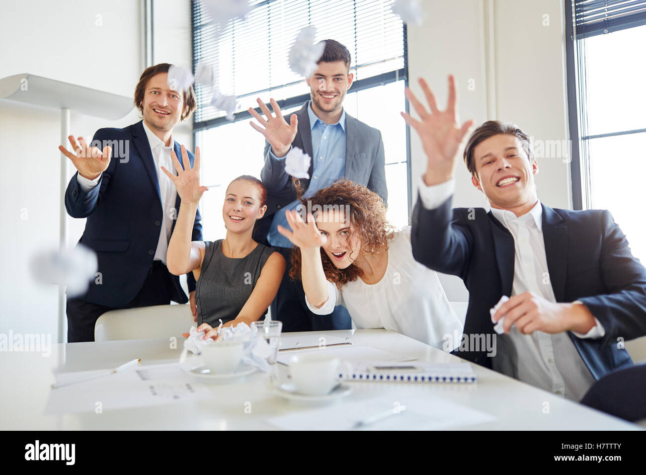 Team having fun throwing paper with enthusiasm Stock Photo - Alamy