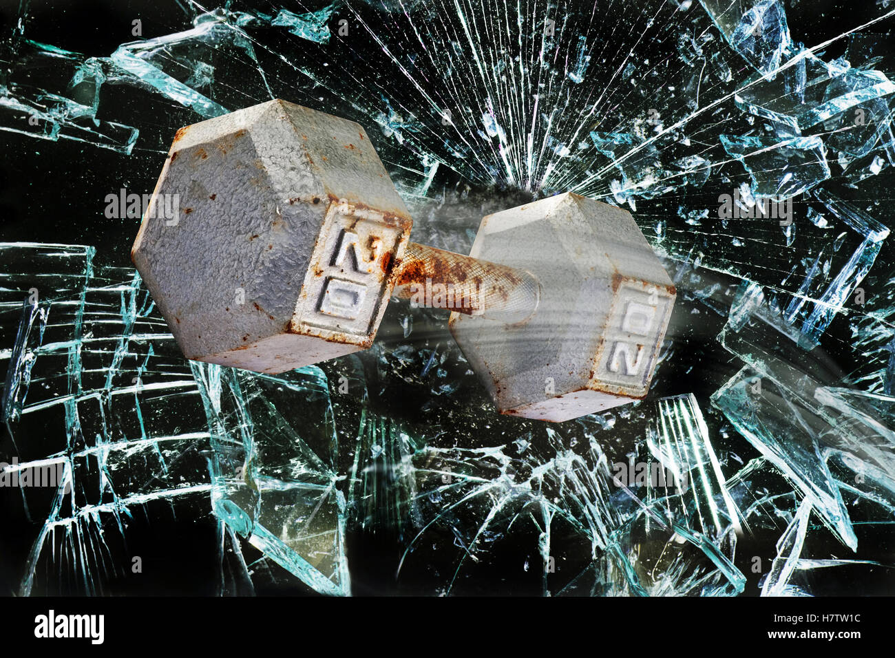 Dumbbell weight through broken glass window Stock Photo - Alamy