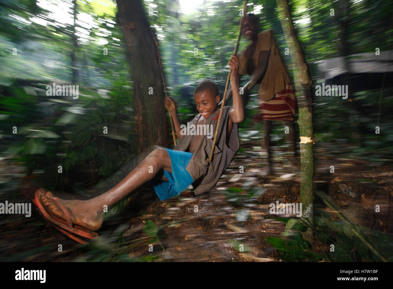 Baka child swinging on liana in the forest, Cameroon Stock Photo - Alamy