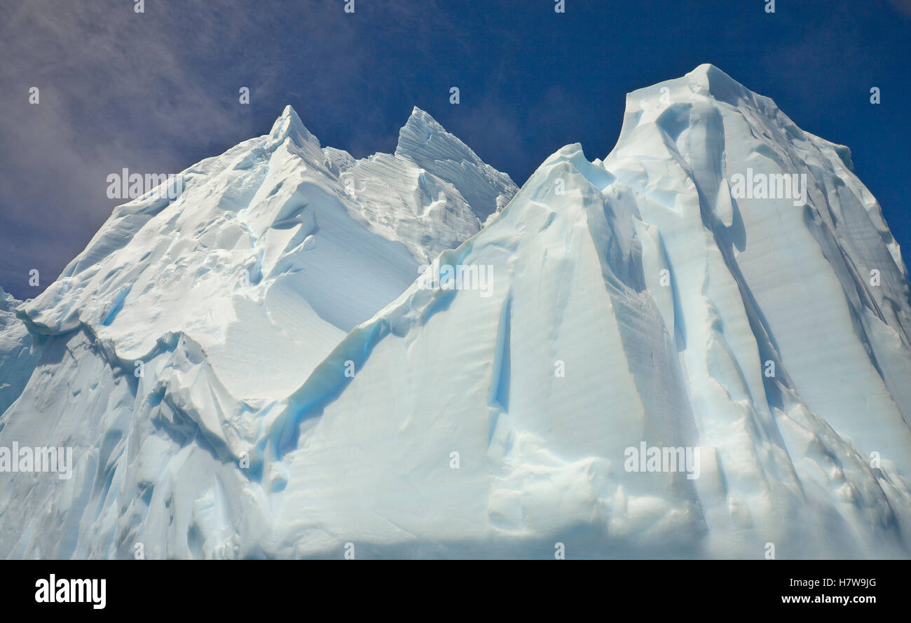 Blue iceberg dramatically sculpted by waves and melting action ...