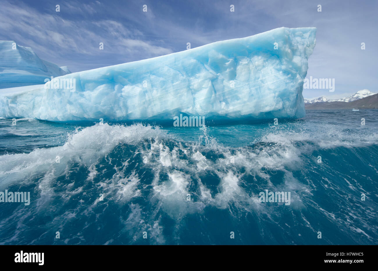 Massive iceberg floating, smashing into waves and melting rapidly due ...