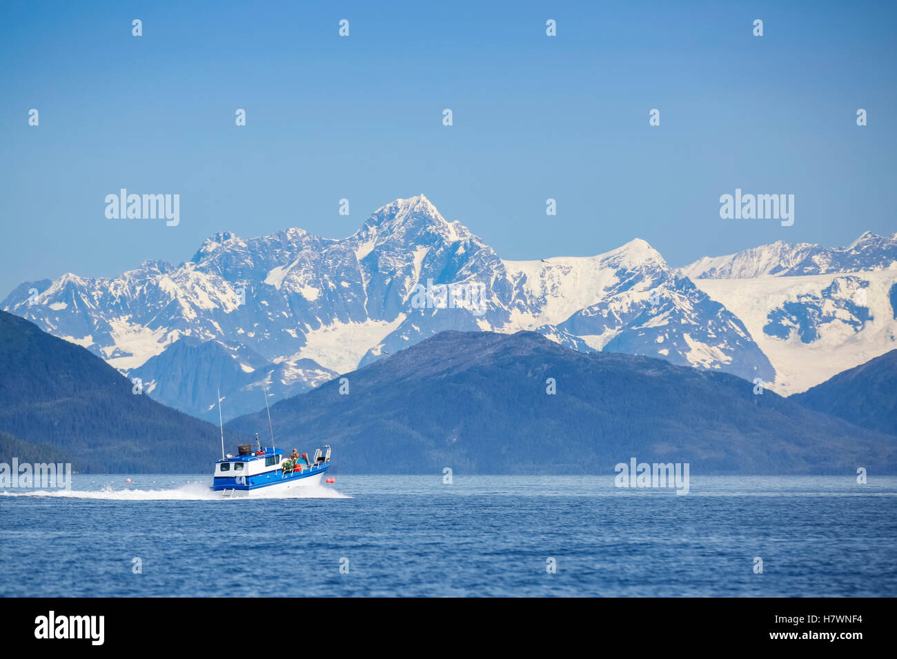 A small fishing boat on the waters of Main Bay, with the Chugach ...