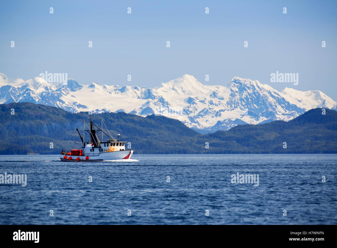 A small fishing boat on the waters of Main Bay, with the Chugach ...