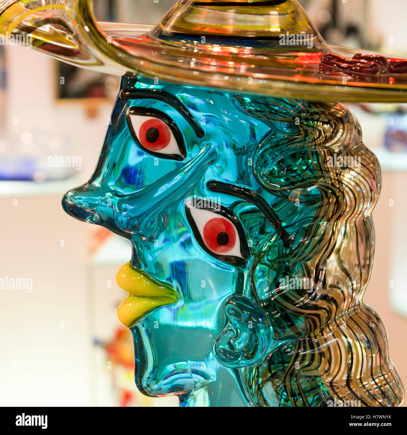 Close up of a colourful glass figure with a uniquely shaped face ...