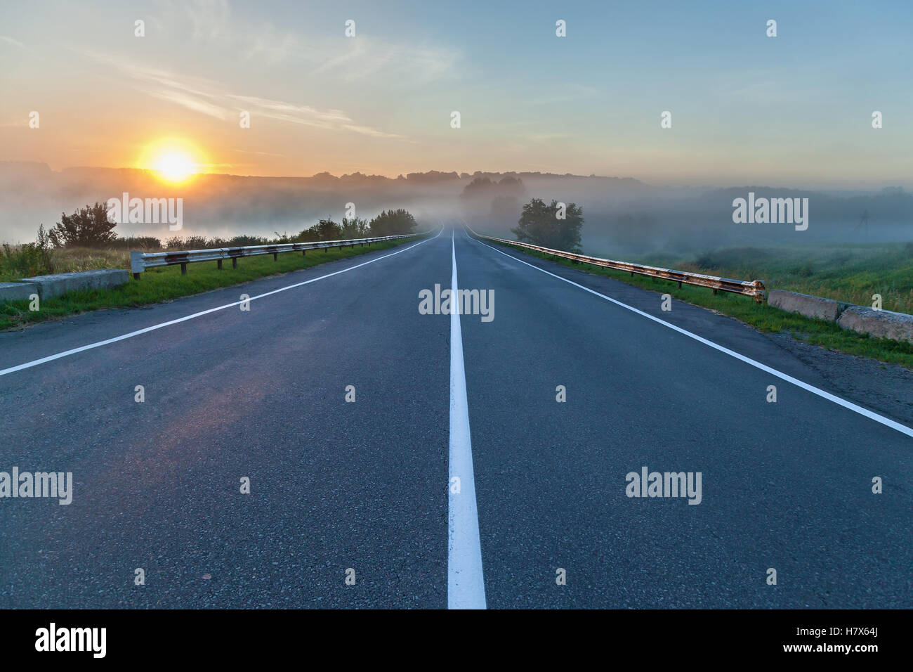 The road and sunrise.The road leading to the morning fog, and the ...