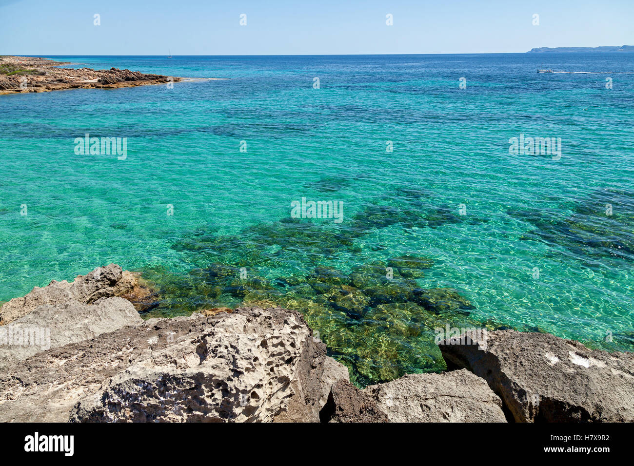 Rocky shore. Rocky shore with crystal clear water through which can be ...