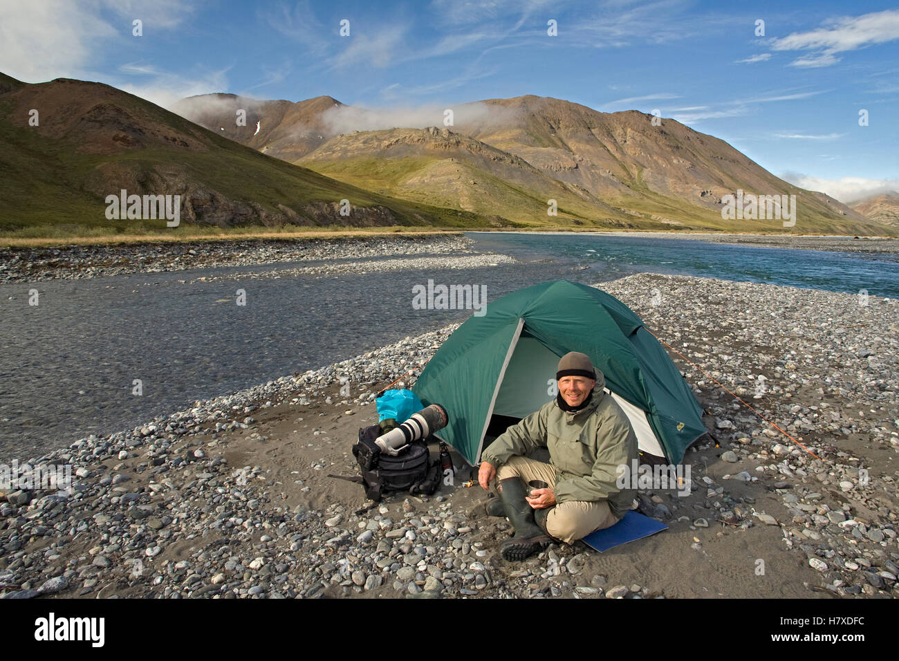 Wildlife photographer Ingo Arndt with his tent on gravel bar, Kongakut ...