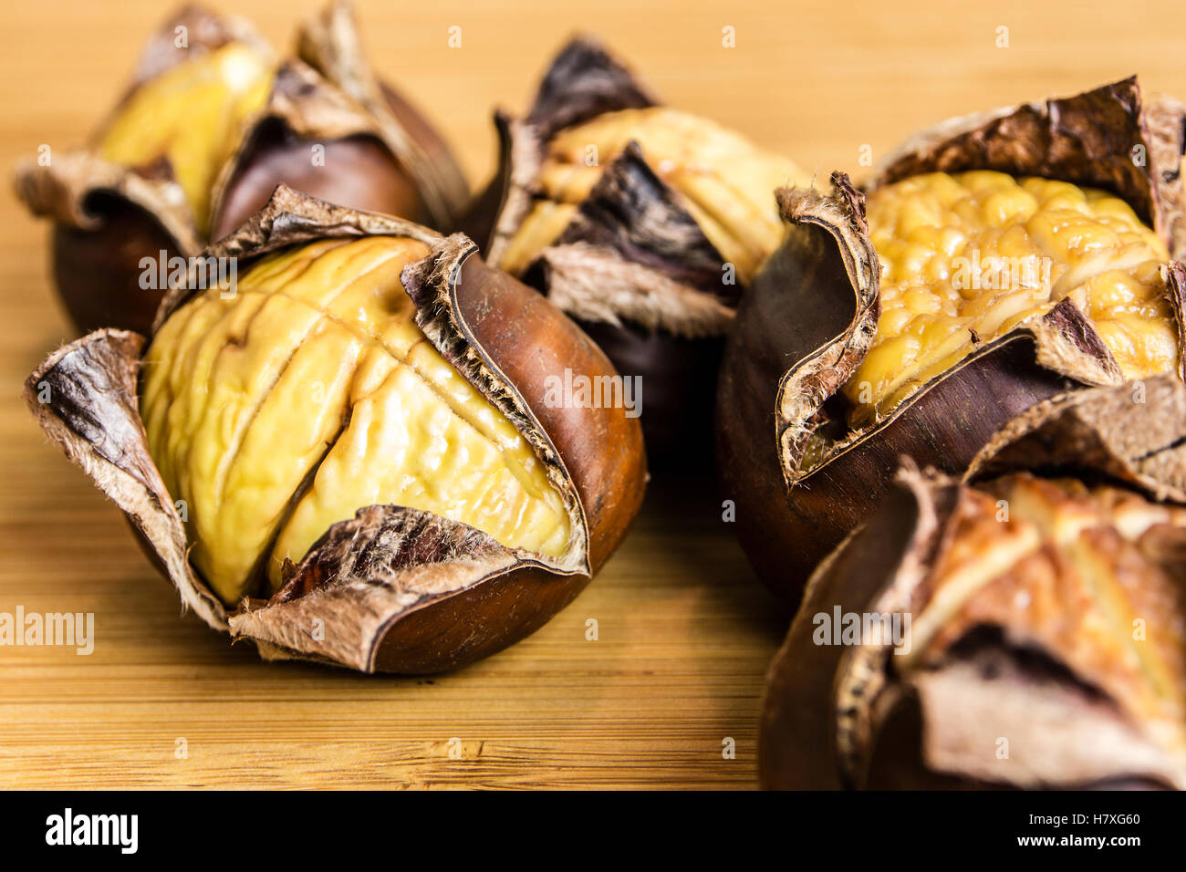 closeup of hot and open roasted chestnuts on wooden background Stock ...