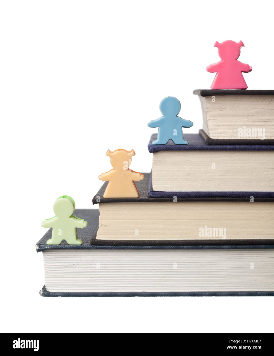 Boy and girl figurines on stack of books isolated on white background ...