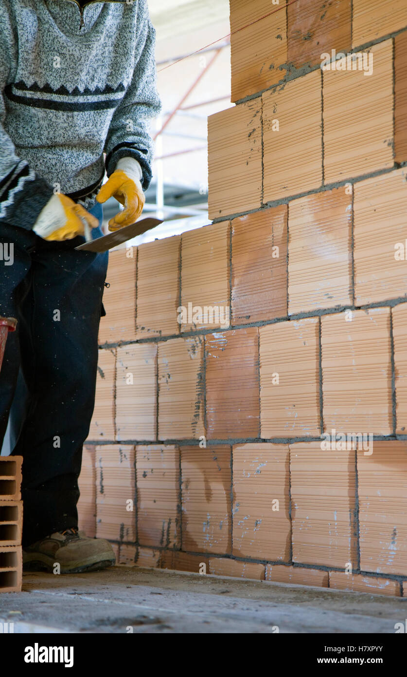 bricklayer working in a building site Stock Photo - Alamy