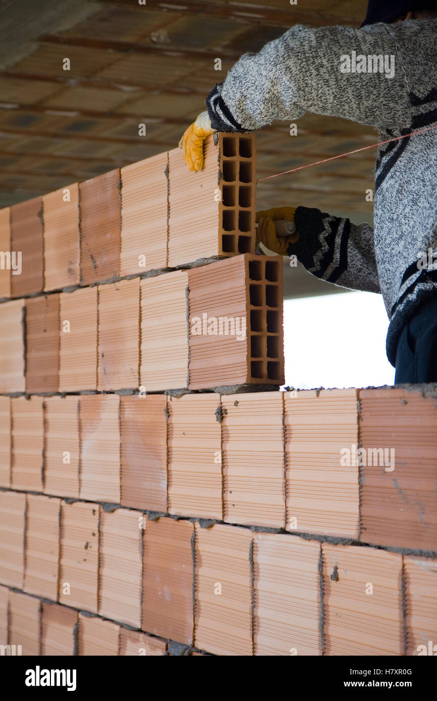 bricklayer working in a building site Stock Photo - Alamy
