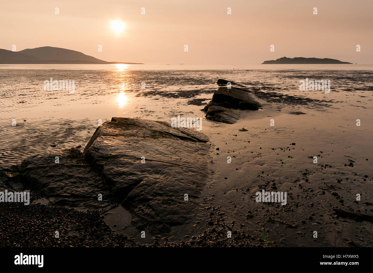 Sunlight glowing at sunset and reflected on the wet beach and ocean ...