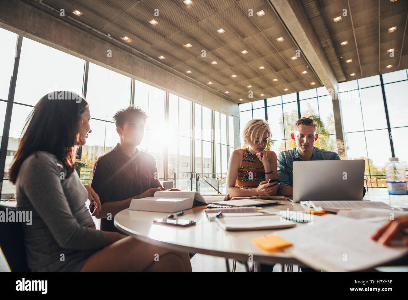 university friends studying together with books and laptop. Group of ...