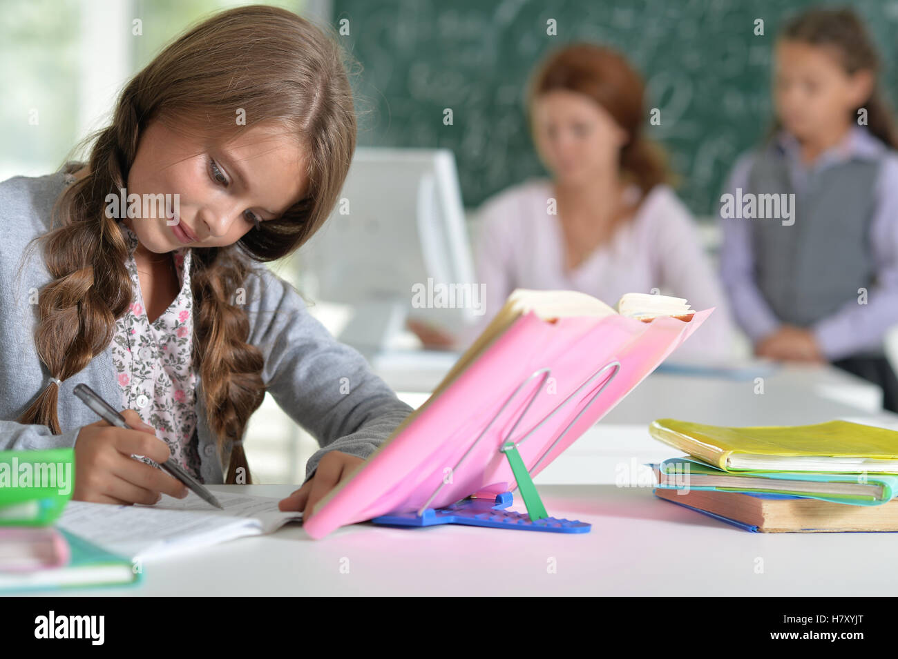 Teacher with two girls at lesson Stock Photo - Alamy