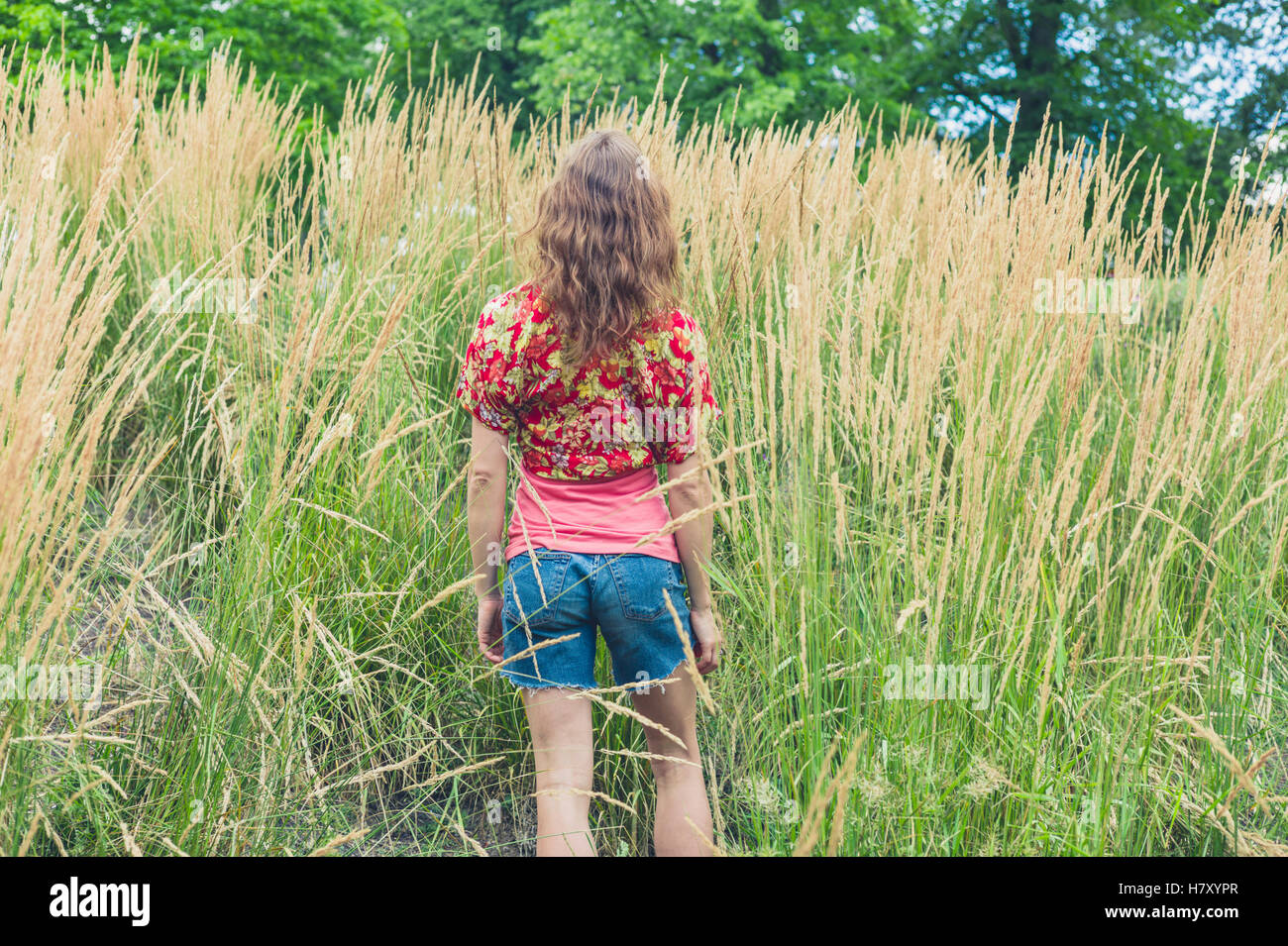 Woman outside standing in tall grass hi-res stock photography and ...
