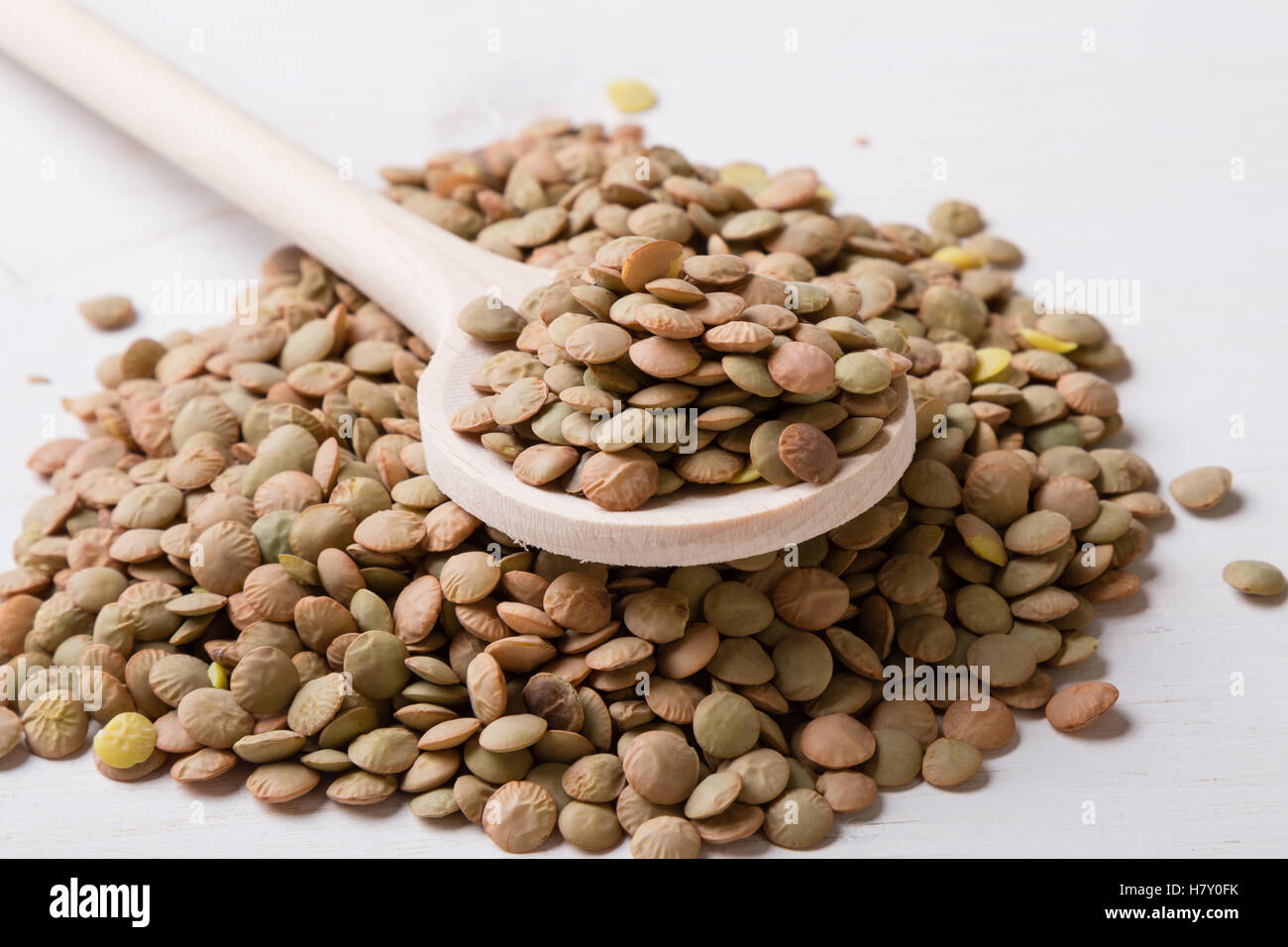 natural organic dry lentils on white table with wooden spoon Stock ...