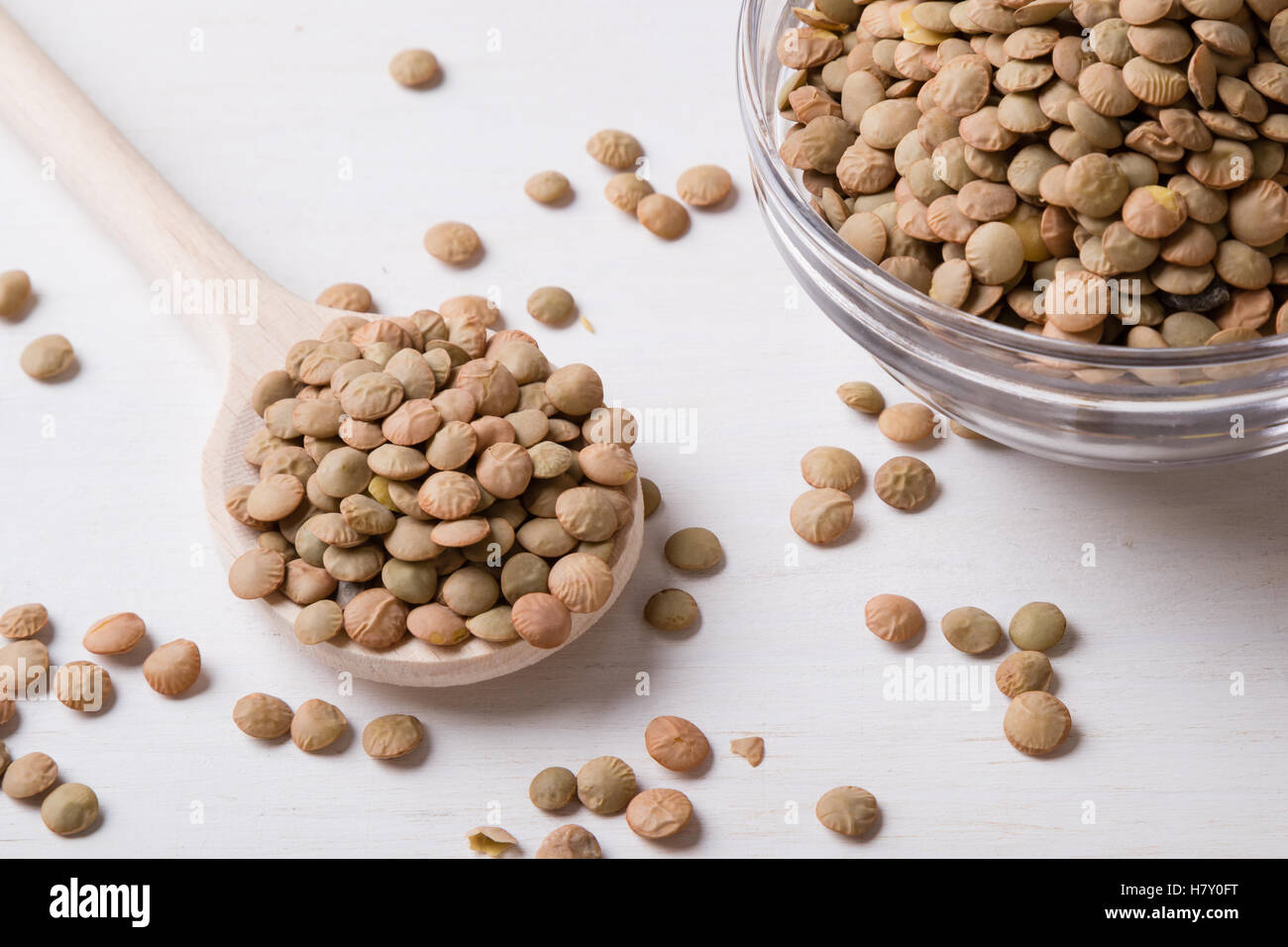 natural organic dry lentils on white table with wooden spoon Stock ...