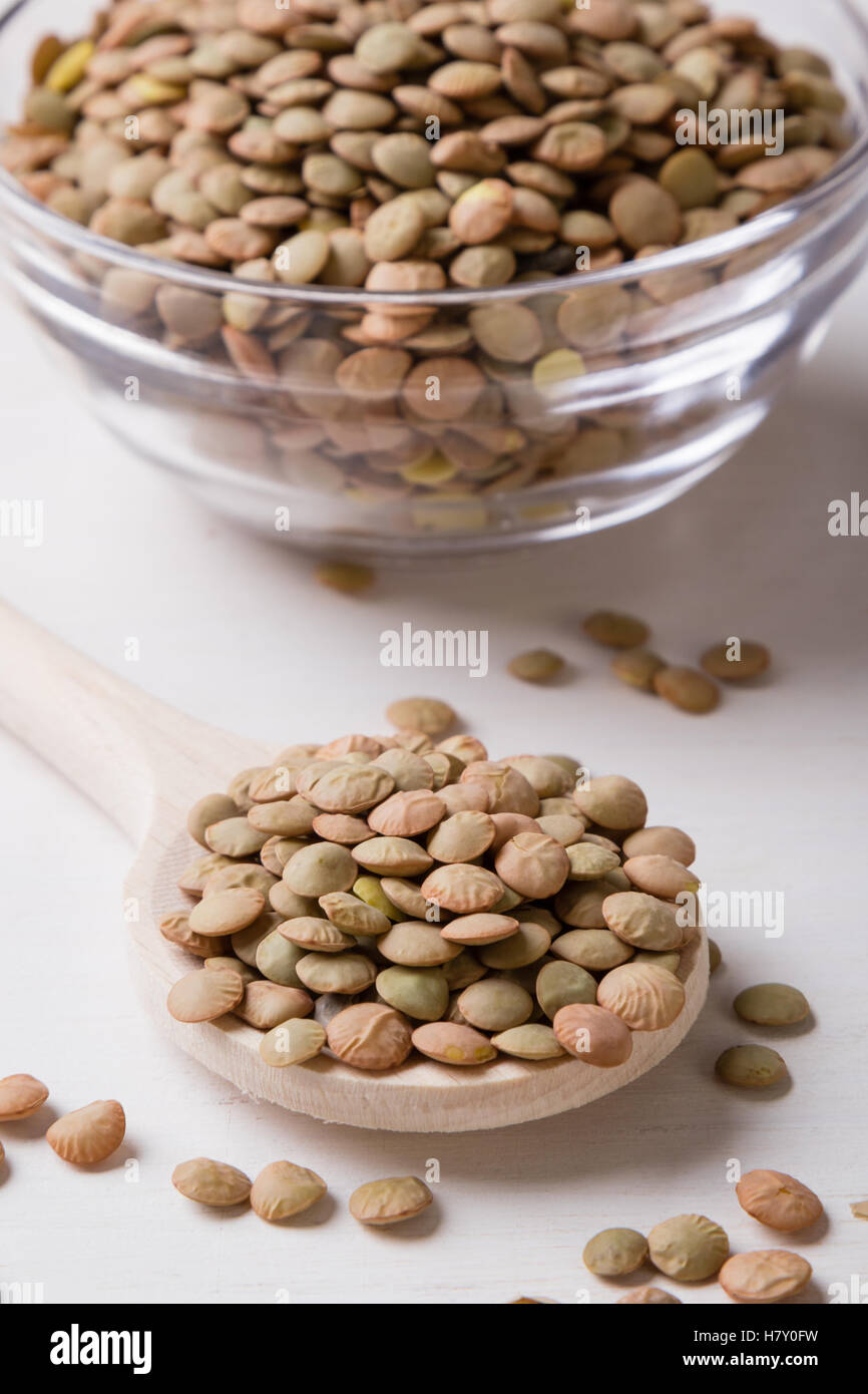 natural organic dry lentils on white table with wooden spoon Stock ...