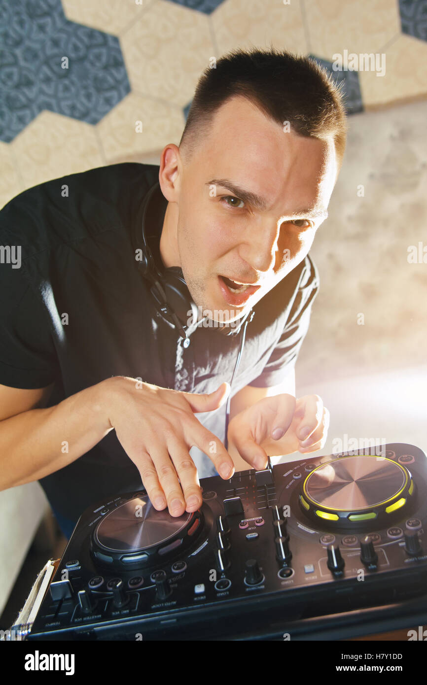 Young man DJ with mixer is working Stock Photo - Alamy