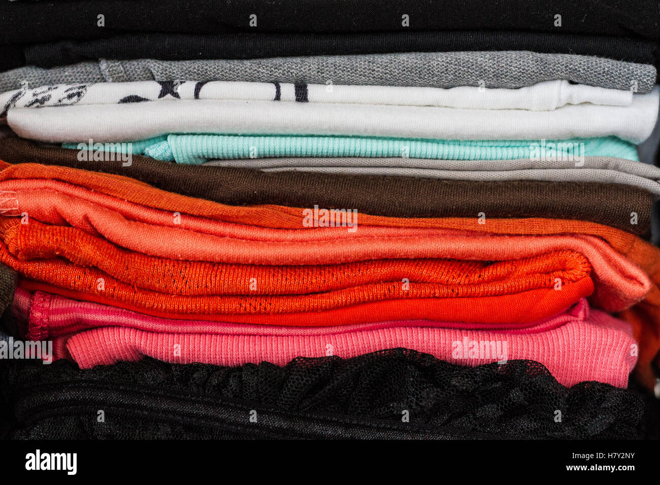A pile of colorful clothes on white Stock Photo - Alamy
