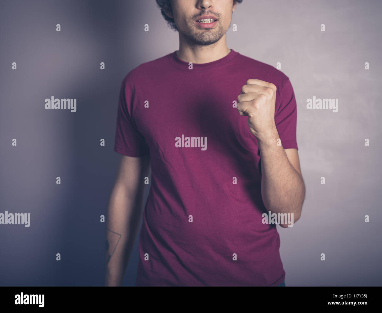 A young man in purple is winning and displaying an awesome fist pump ...