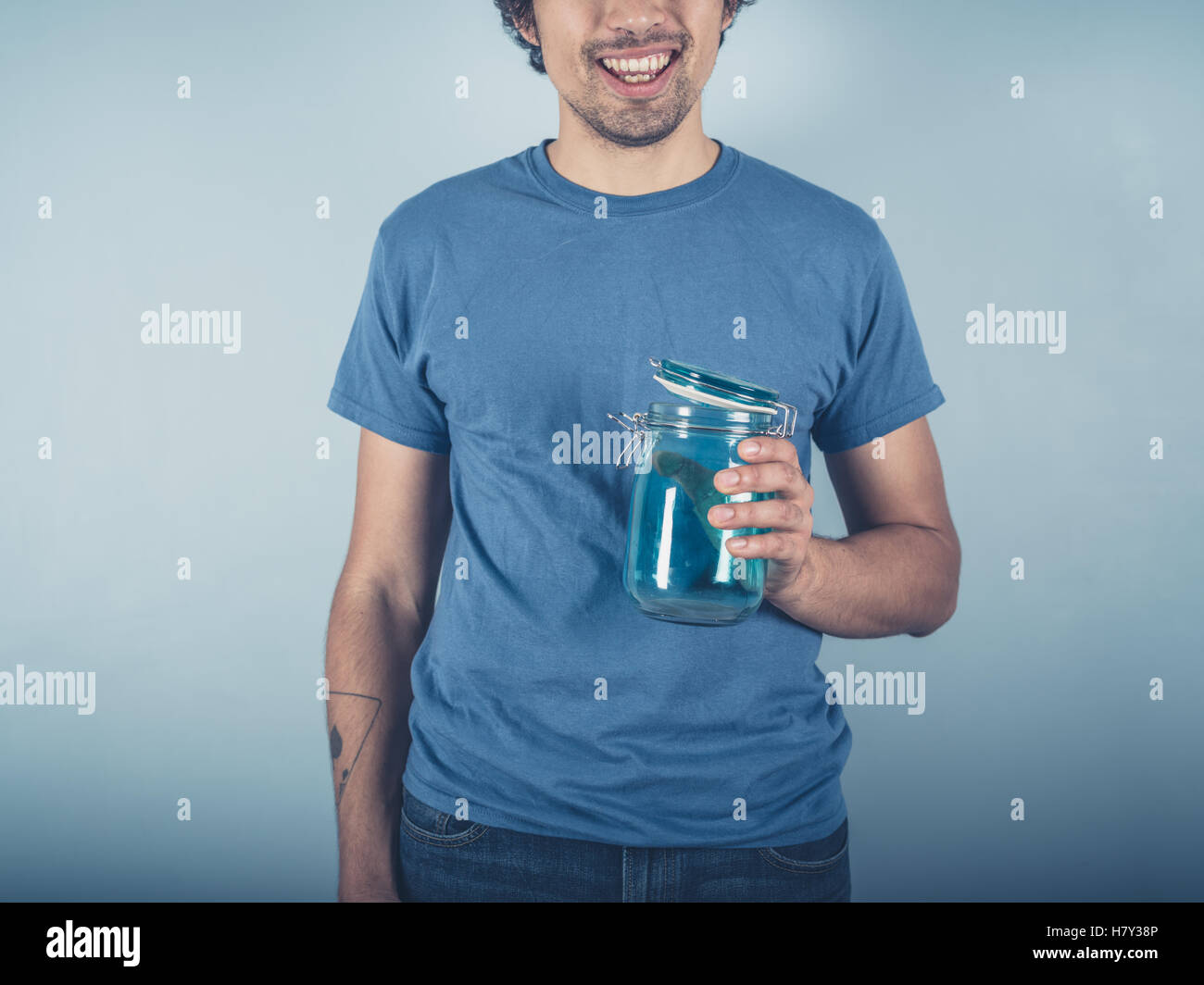 A smiling young man is holding a jam jar Stock Photo - Alamy