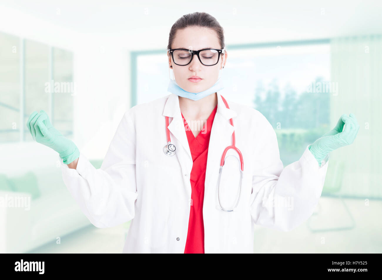 Young brunette medic or doctor doing yoga and relaxing with eyes closed ...