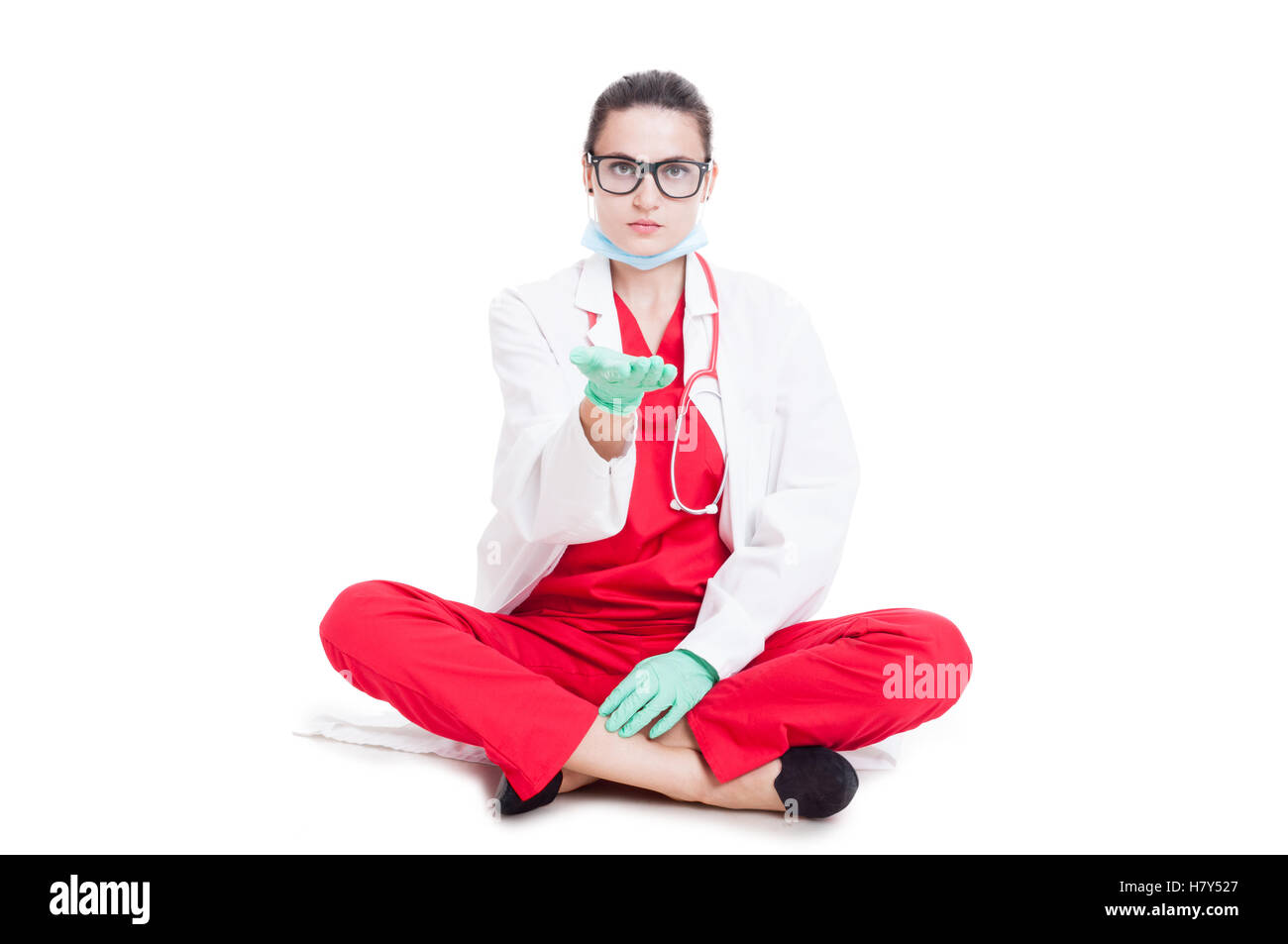 Beautiful woman medic sitting down in yoga pose and offer something to ...
