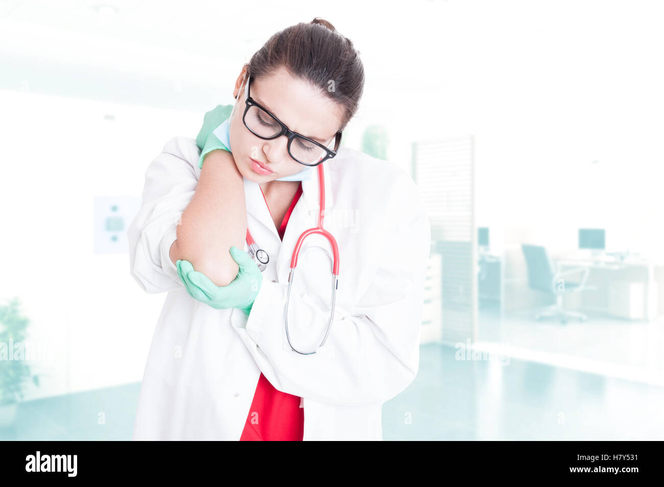 Beautiful female medic treating her wounded elbow as physical recovery ...