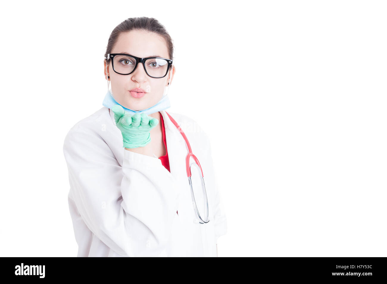 Attractive young medic sending a kiss and flirting isolated on white ...
