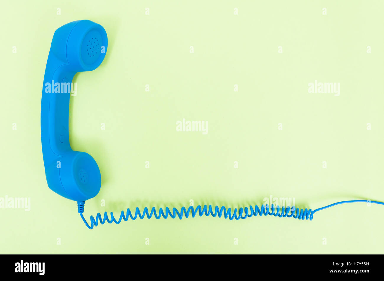 Retro telephone receiver with cord isolated on green background with ...