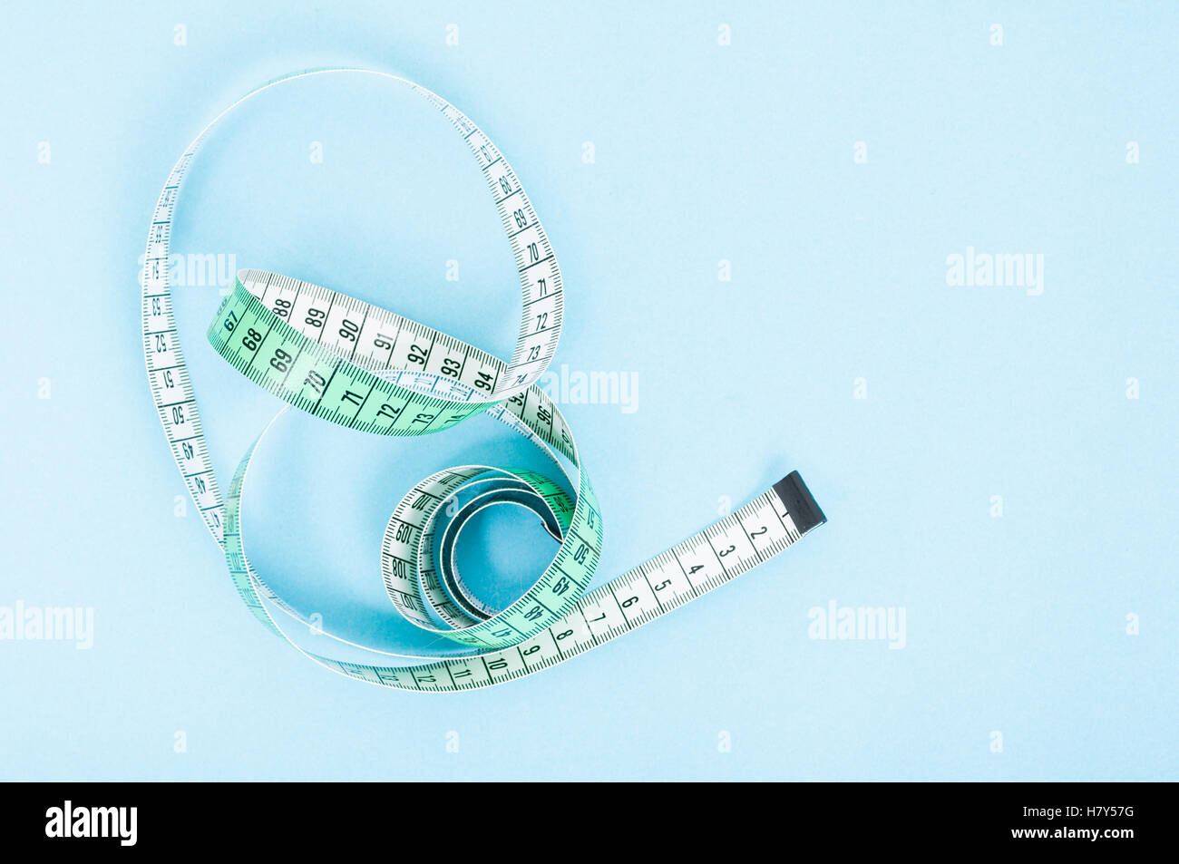 Swirl measuring tape of the tailor isolated on blue background with ...