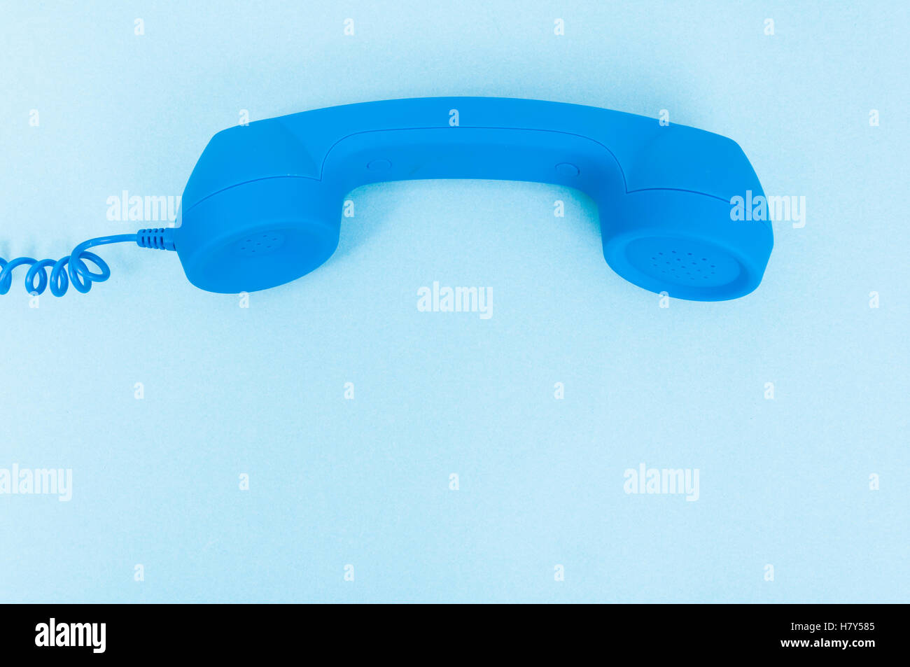 Side view of retro phone receiver on blue background with copyspace ...
