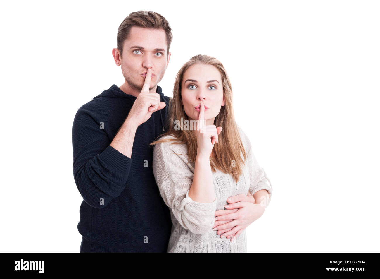 Cute couple making shush gesture with index finger isolated on white ...