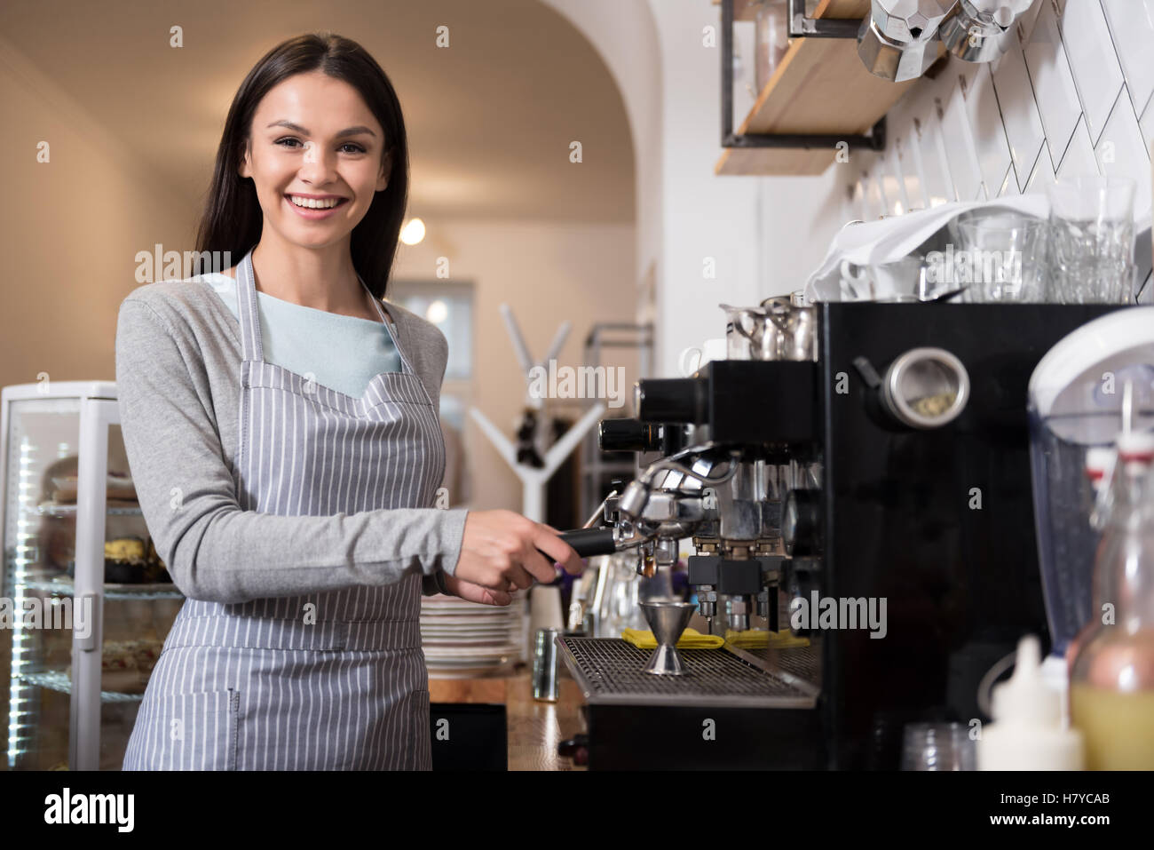 Happy pretty woman using coffee machine Stock Photo - Alamy