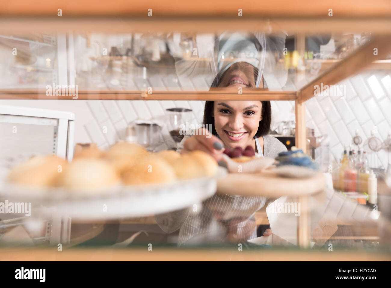 Cheerful pretty smiling woman getting cake from display stand Stock ...