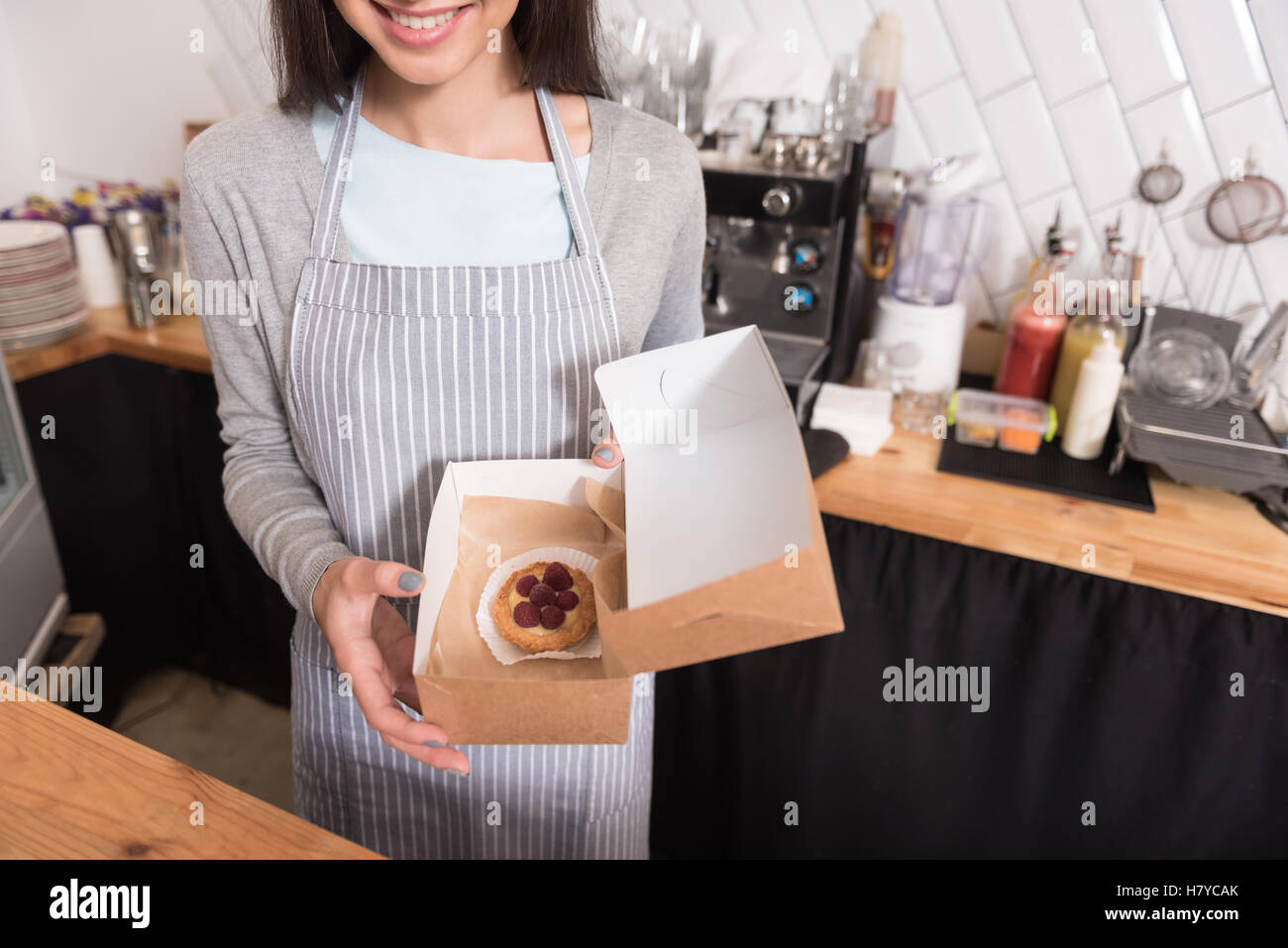 Beautiful smiling waitress presenting cake in a cafe Stock Photo - Alamy