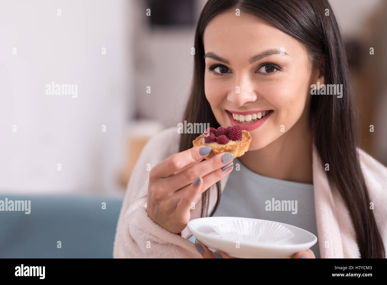 Beautiful young woman eating cupcake Stock Photo - Alamy