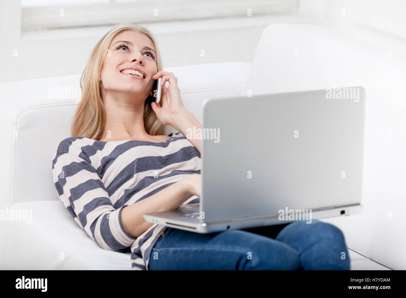 woman laying on the couch with laptop Stock Photo - Alamy