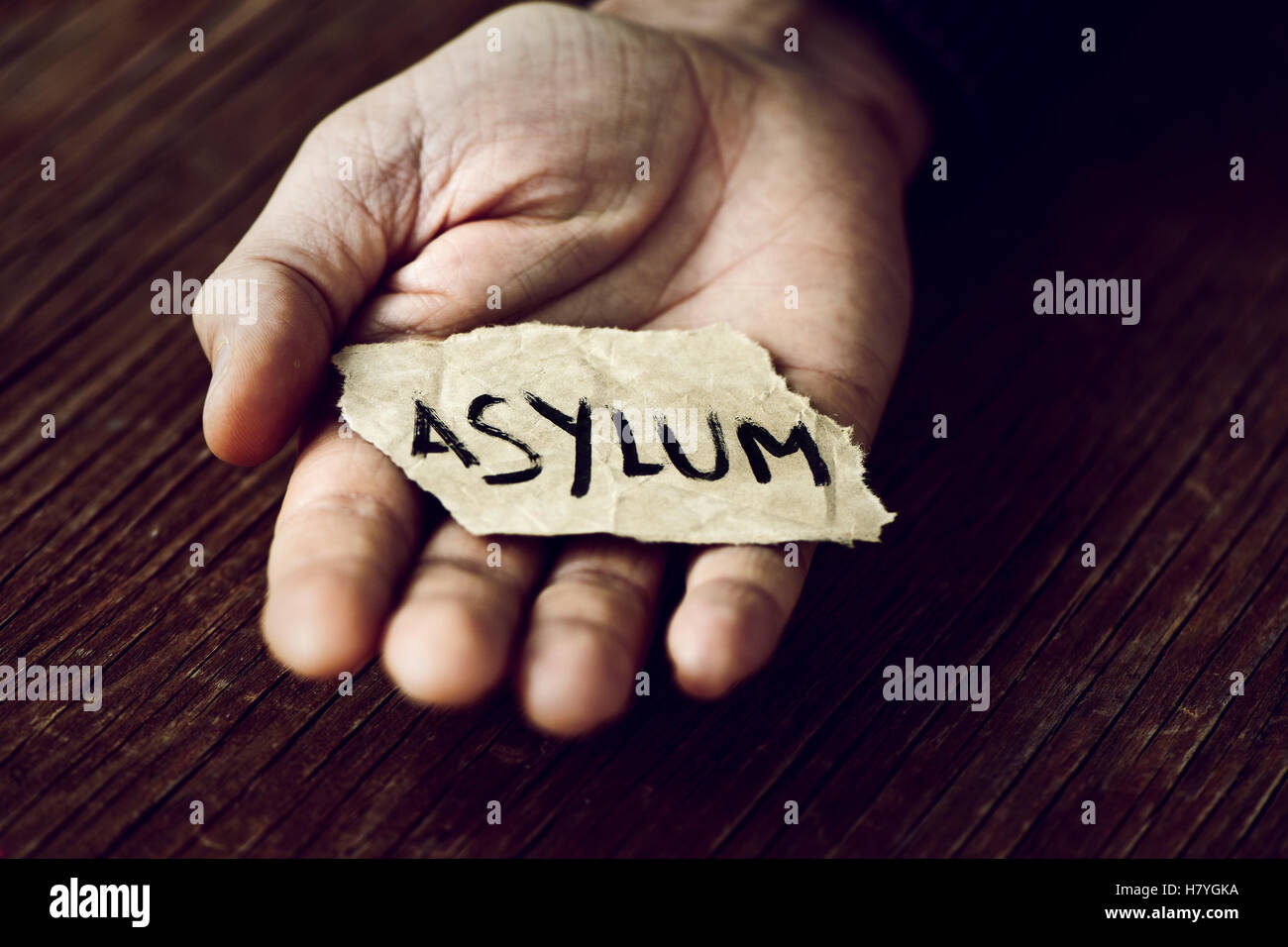 closeup of the hand of a young man with a piece of paper with the word ...